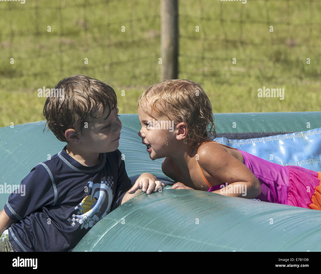 boy and girl talking to each other over a waterslide pool. Clermont ...