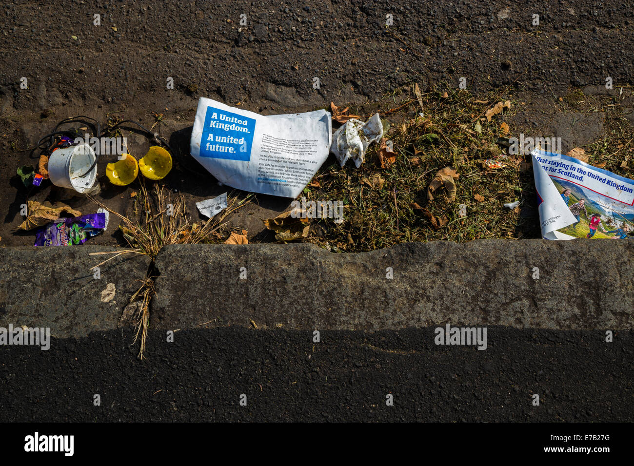 some litter that had blown next to the curb of a path Stock Photo - Alamy