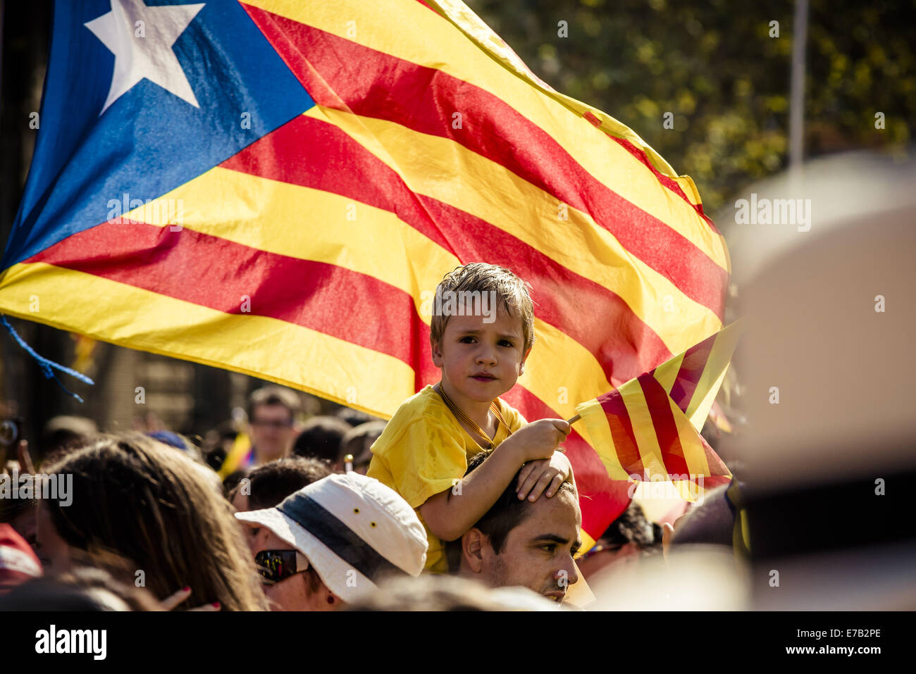 Barcelona, Spain. 11th Sep, 2014. A young child rides on the shoulders ...