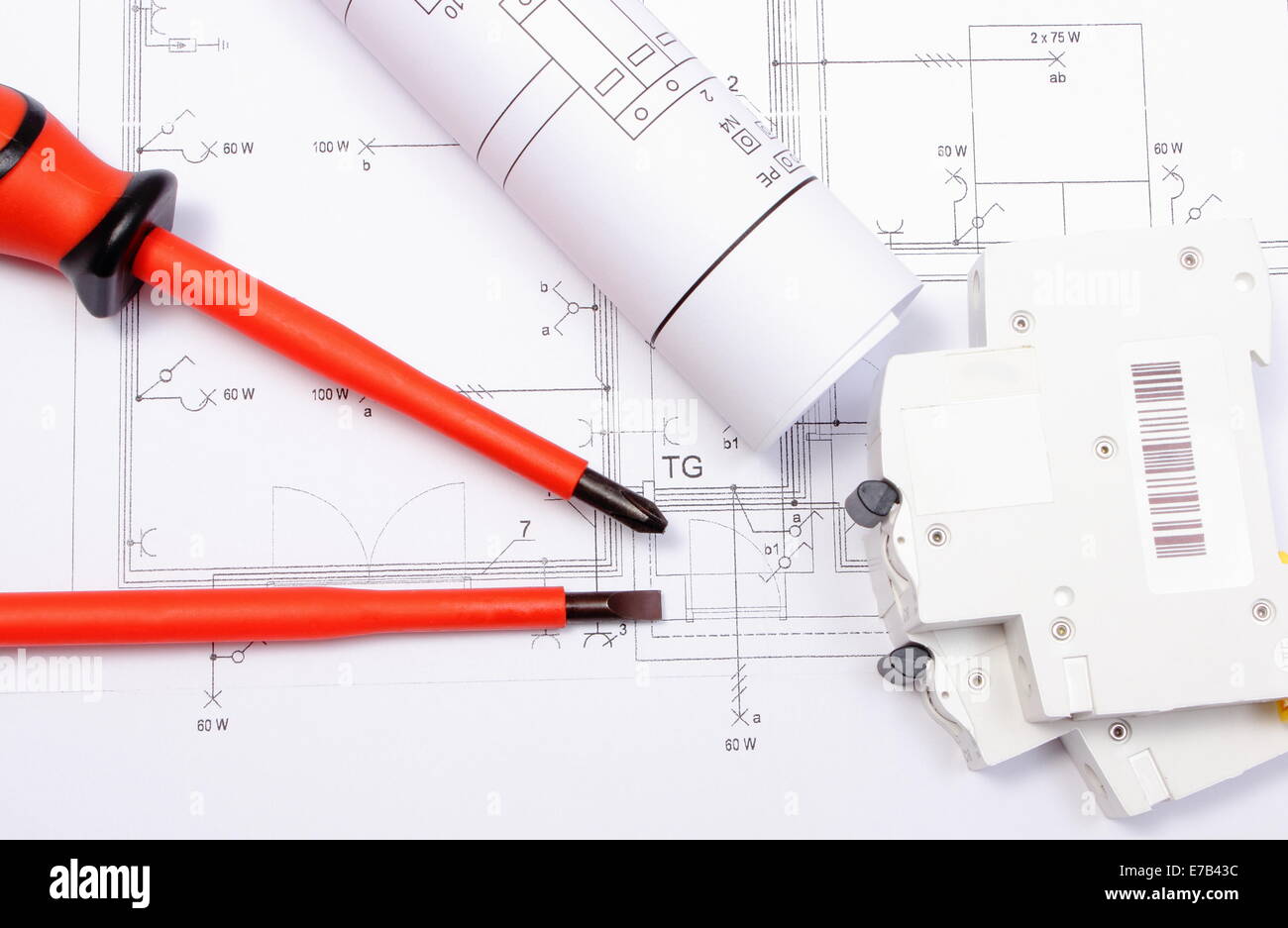 Rolled electrical diagrams, electric fuse and red screwdrivers lying on ...