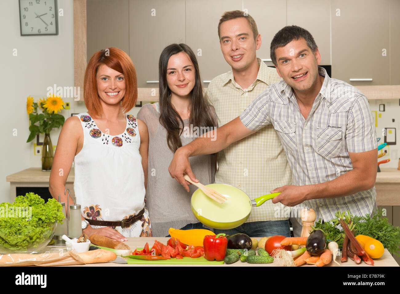 front view of young caucasian people standing in kitchen, cooking Stock ...