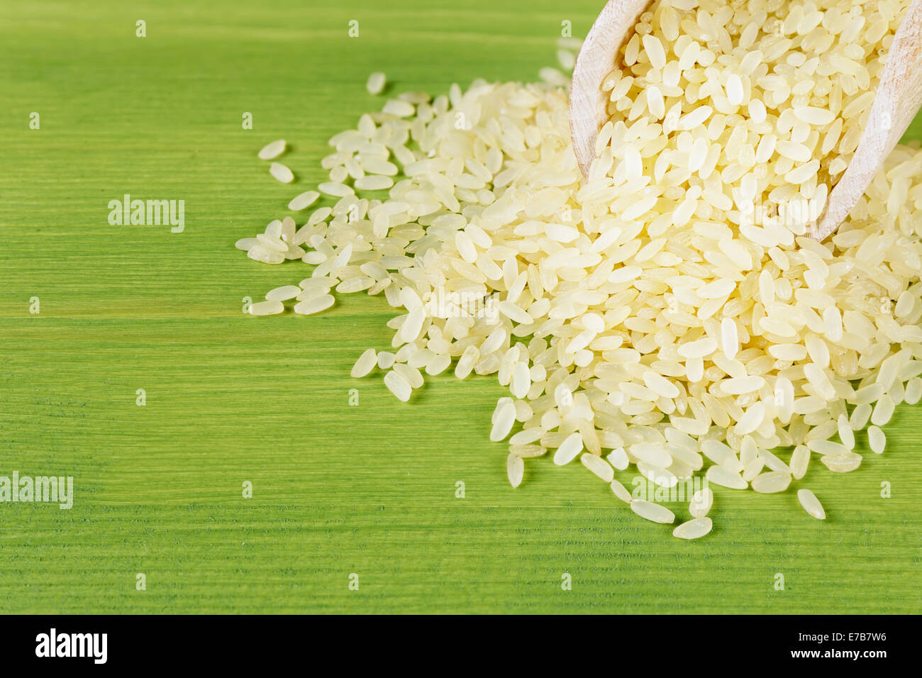 closeup scoop of rice on wooden background Stock Photo - Alamy