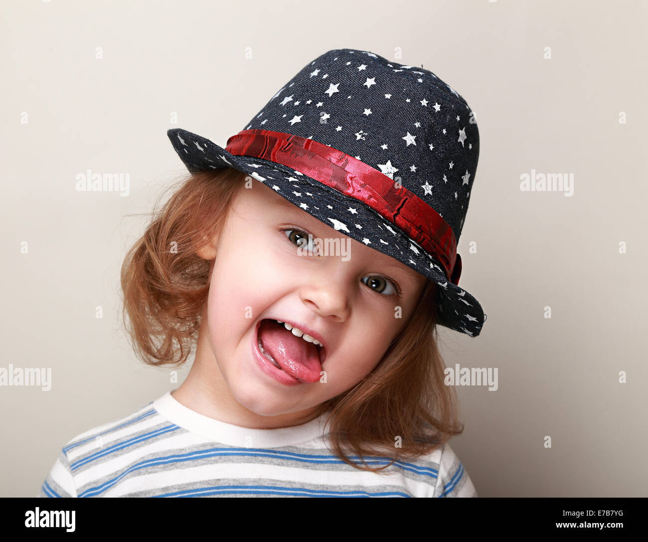 Happy grimacing kid in hat showing the tongue. Closeup Stock Photo - Alamy