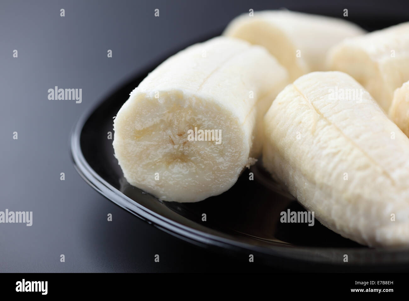Chopped banana in a black plate on black background. Close-up Stock ...