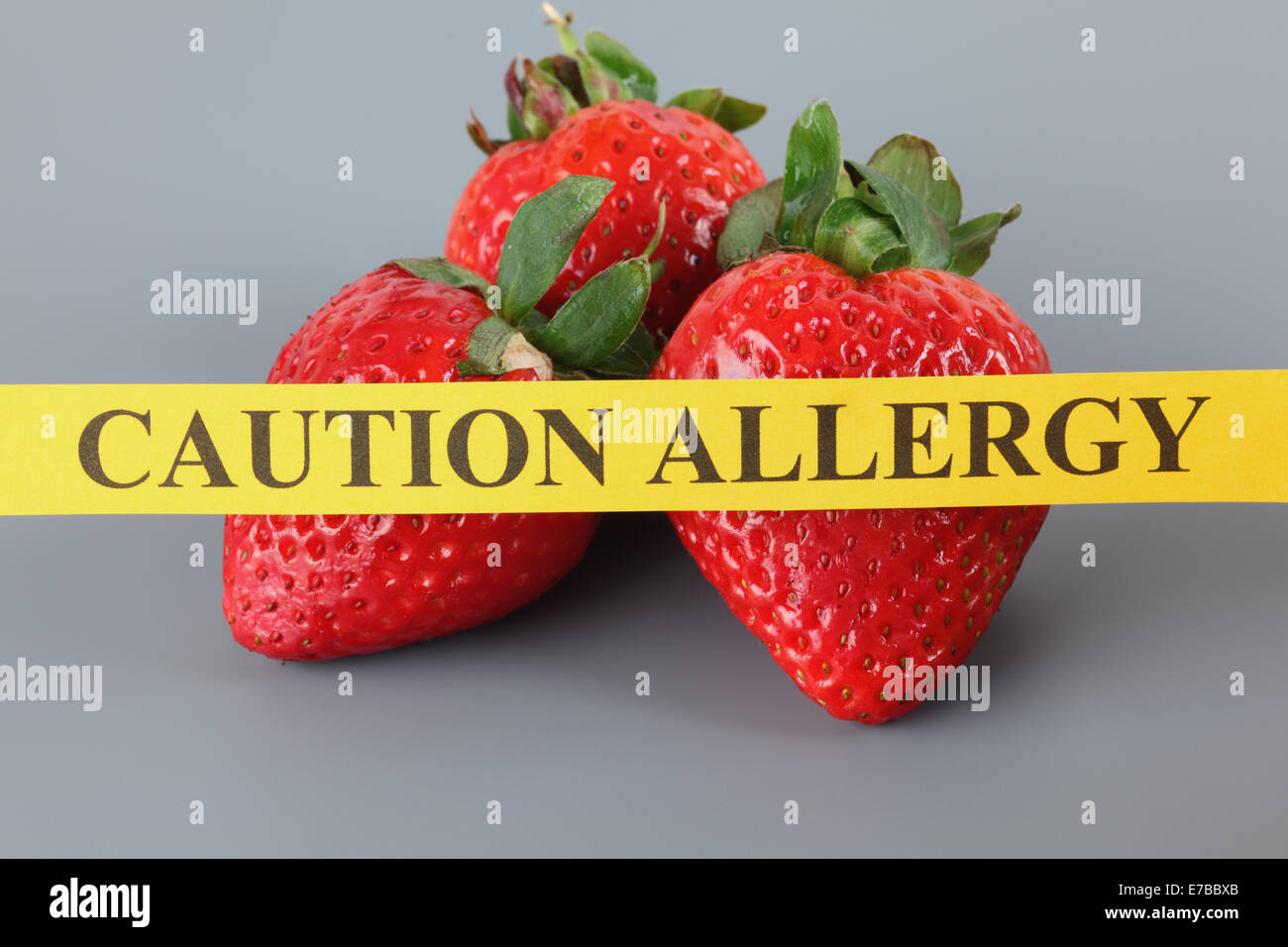 Strawberry allergy concept. Yellow paper with the words "Caution ...