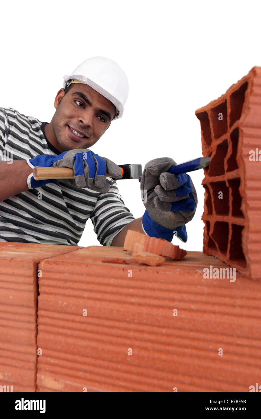 Mason chiseling away at brick Stock Photo - Alamy