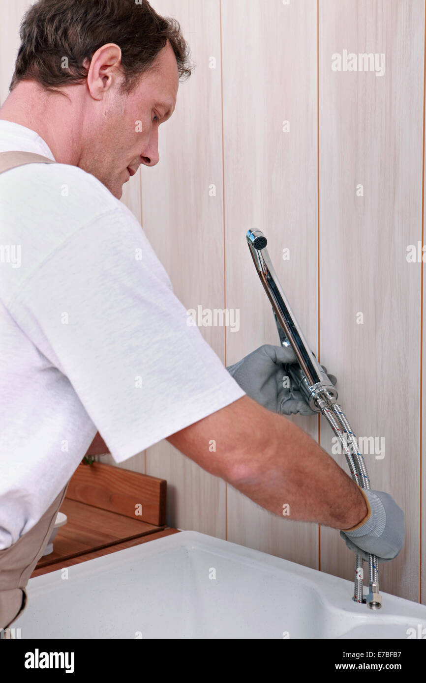 Plumber fitting new sink Stock Photo - Alamy