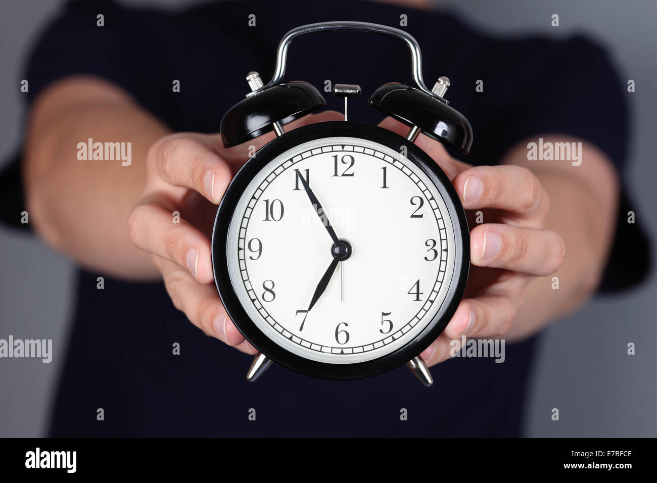 It's almost seven o'clock!. Woman's hands holding and showing alarm ...