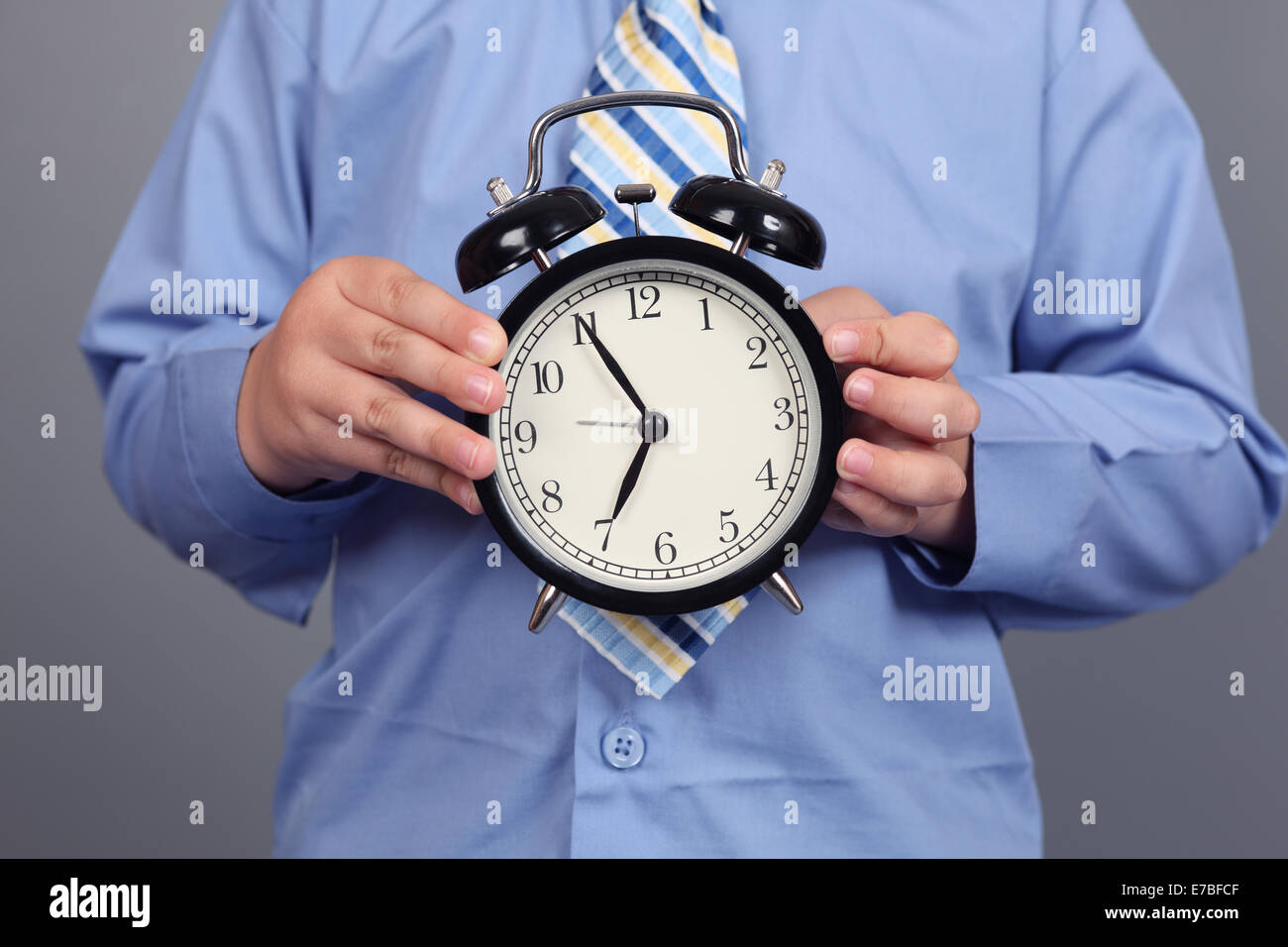 Young boy showing alarm clock Stock Photo - Alamy