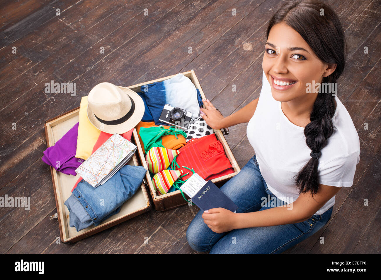 Happy girl packing her suitcase Stock Photo - Alamy