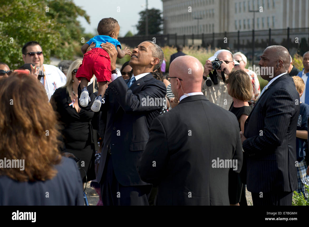 US President Barack Obama picks up a small child in the crowd after ...