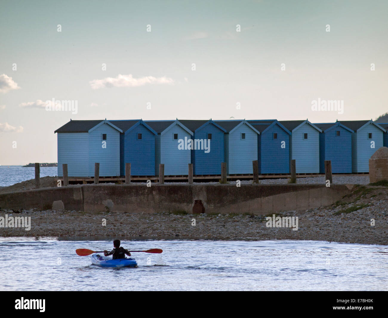 In Charmouth a boy canoes on the River Char, as it reaches the sea ...