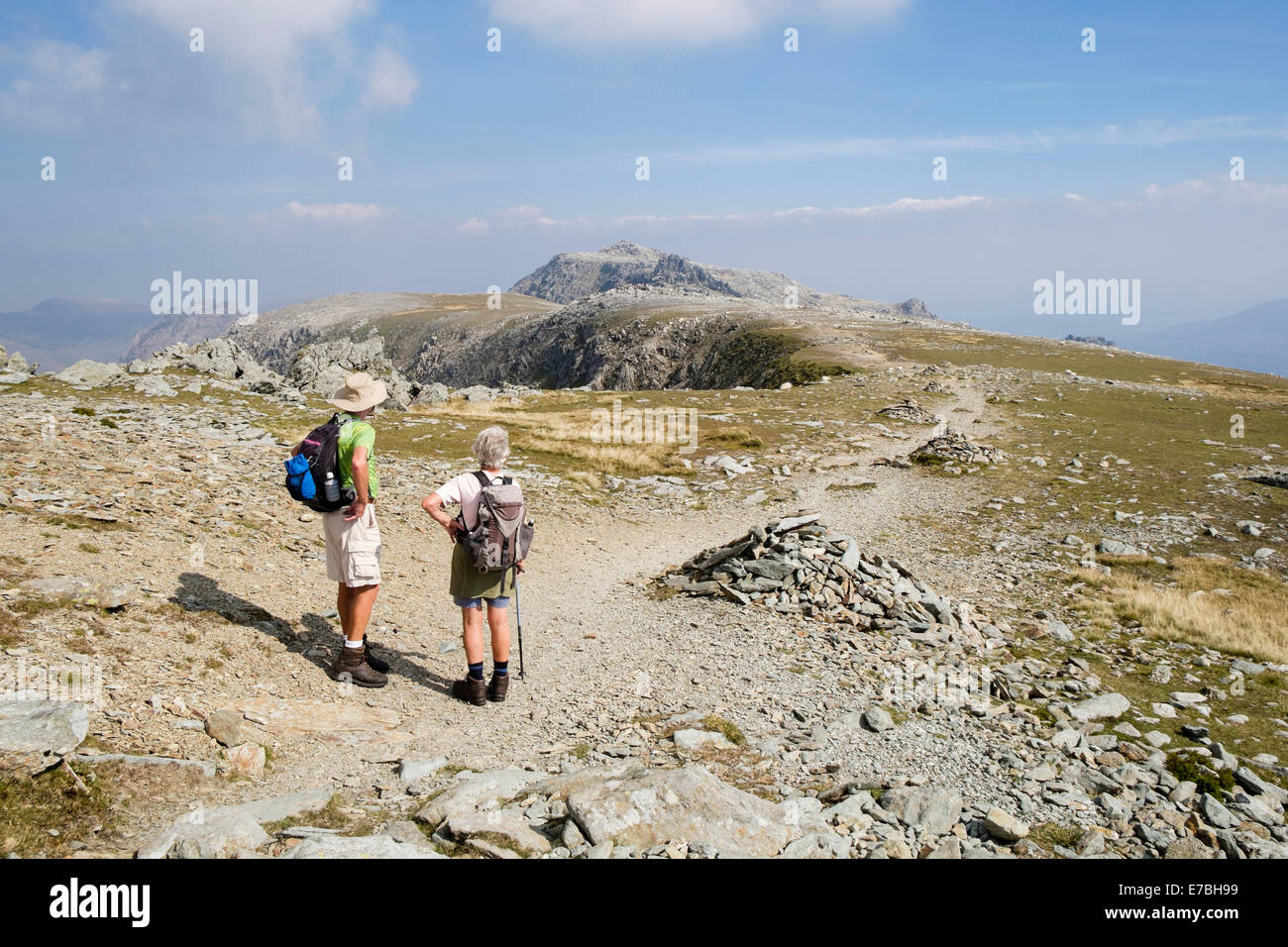 Senior hikers hiking on cairned path from Glyder Fawr to Glyder Fach ...
