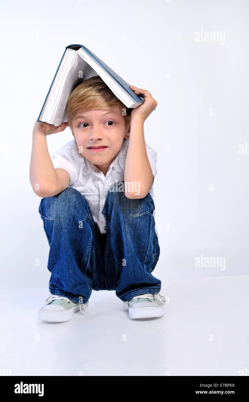 Young child boy hide with book Stock Photo - Alamy