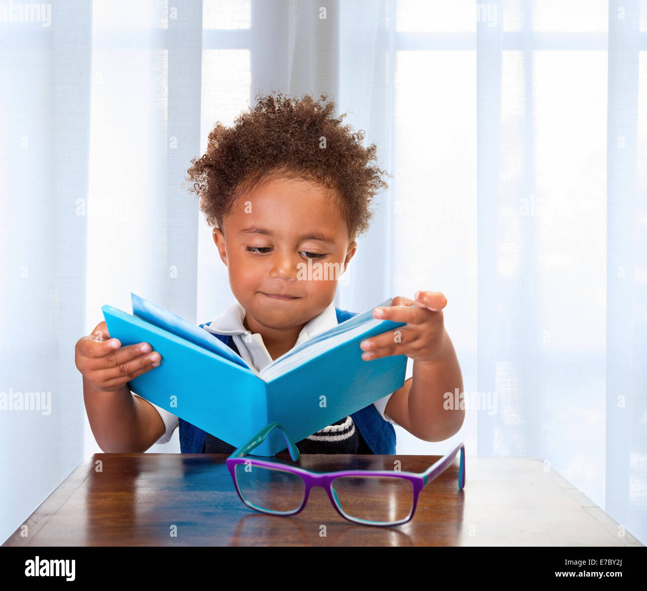 Little schoolboy read book in classroom, adorable african child ...