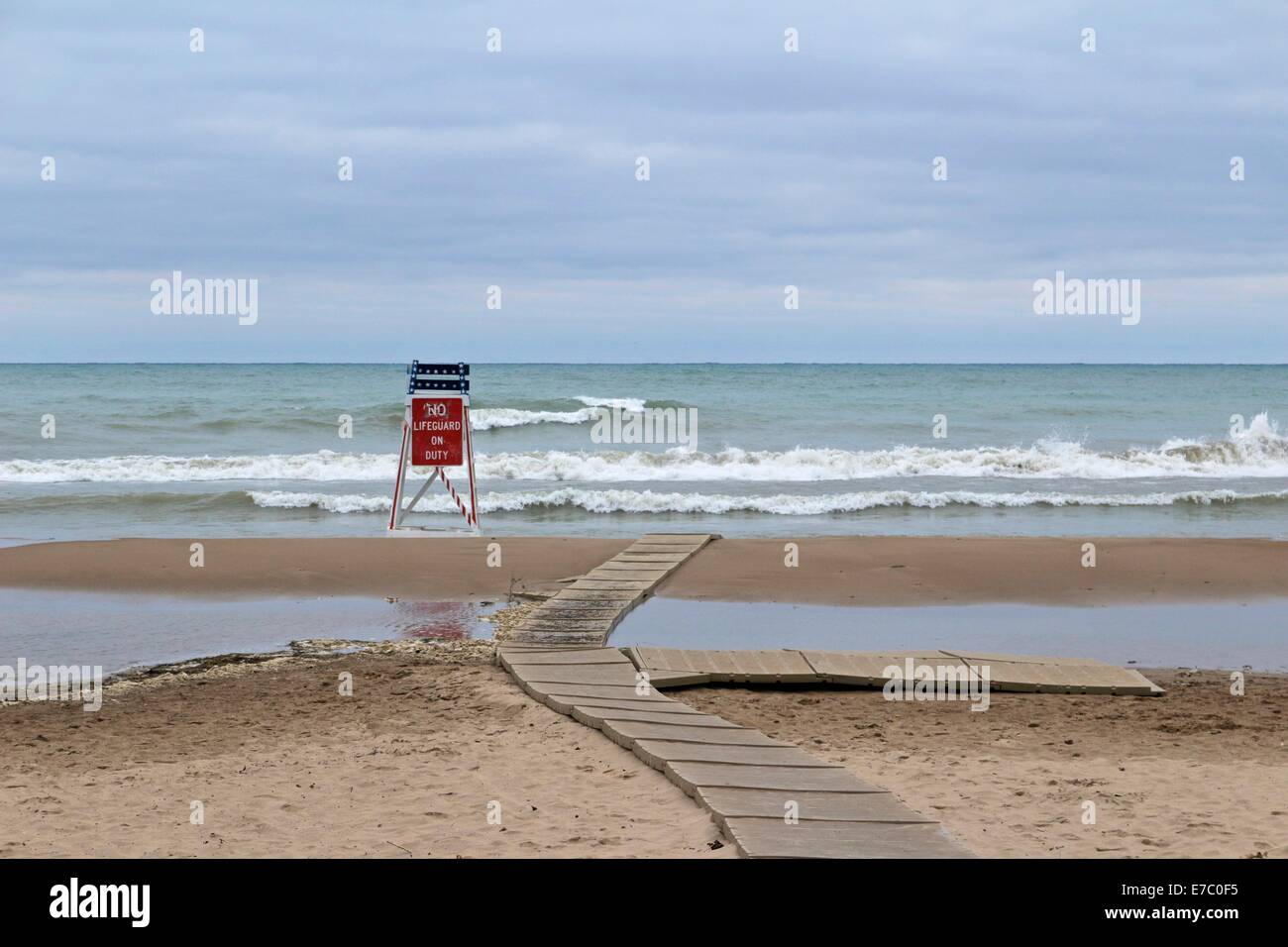 Empty lifeguard tower with No Lifeguard on Duty sign on deserted beach ...