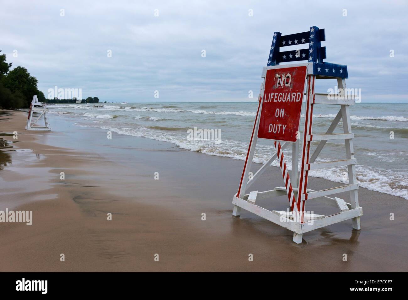 Empty lifeguard tower with No Lifeguard on Duty sign on deserted beach ...
