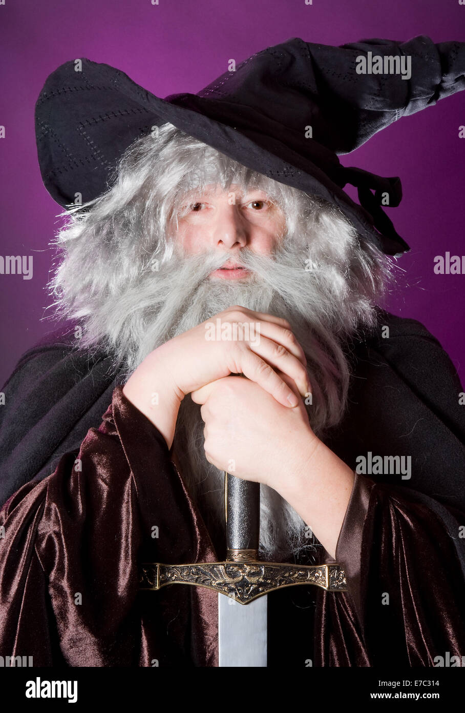 Magician leaning on an ancient magical sword Stock Photo - Alamy
