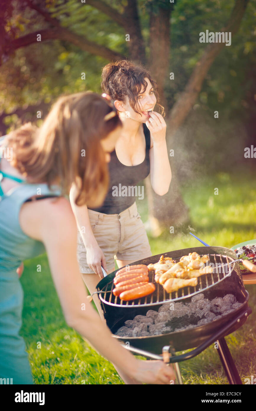 Two pretty girls making food on grill Stock Photo - Alamy