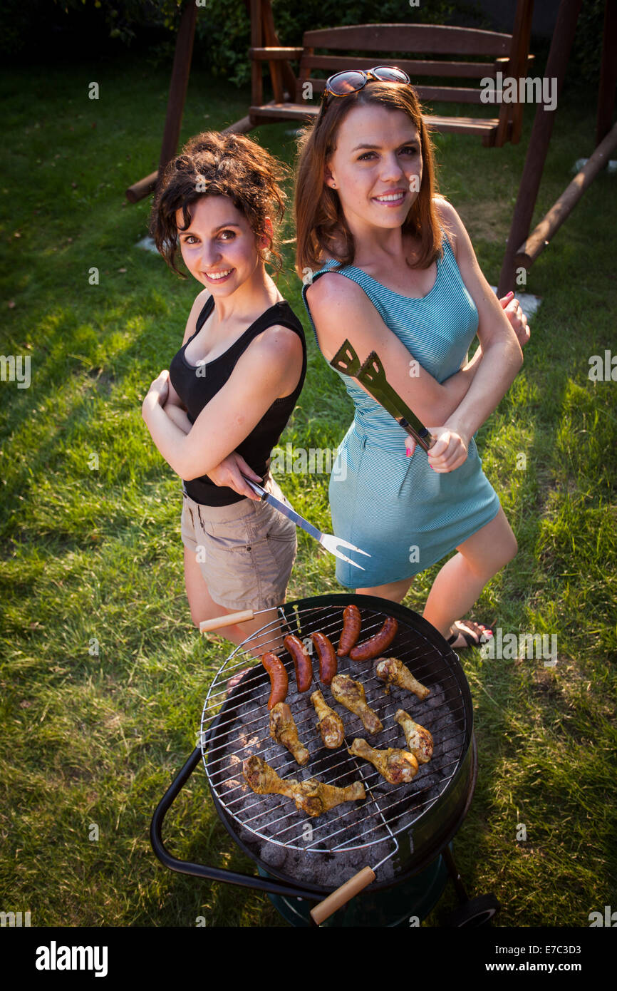 Two pretty girls making food on grill Stock Photo - Alamy