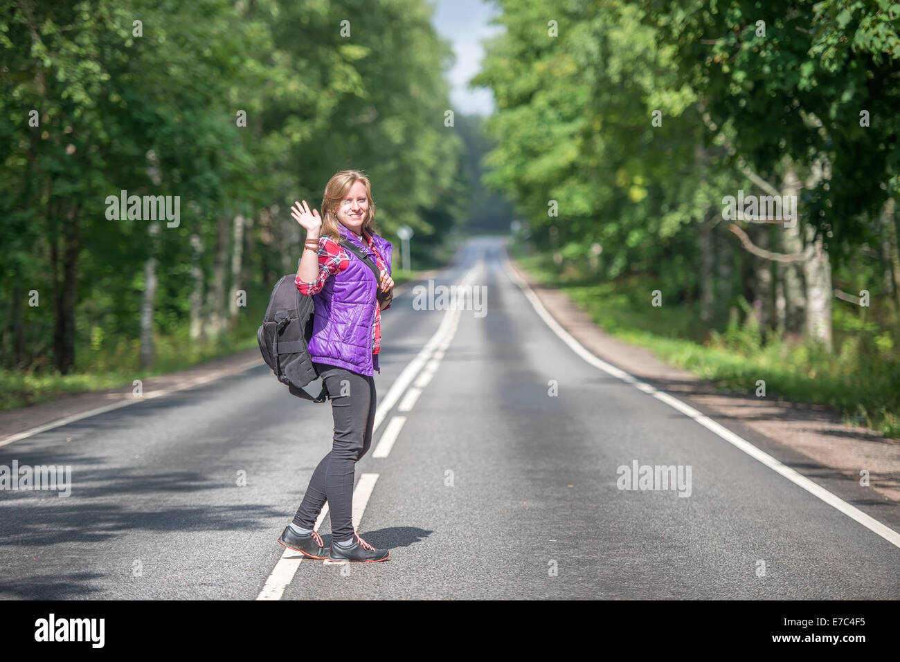 Beautiful girl with backpack walking on the road Stock Photo - Alamy