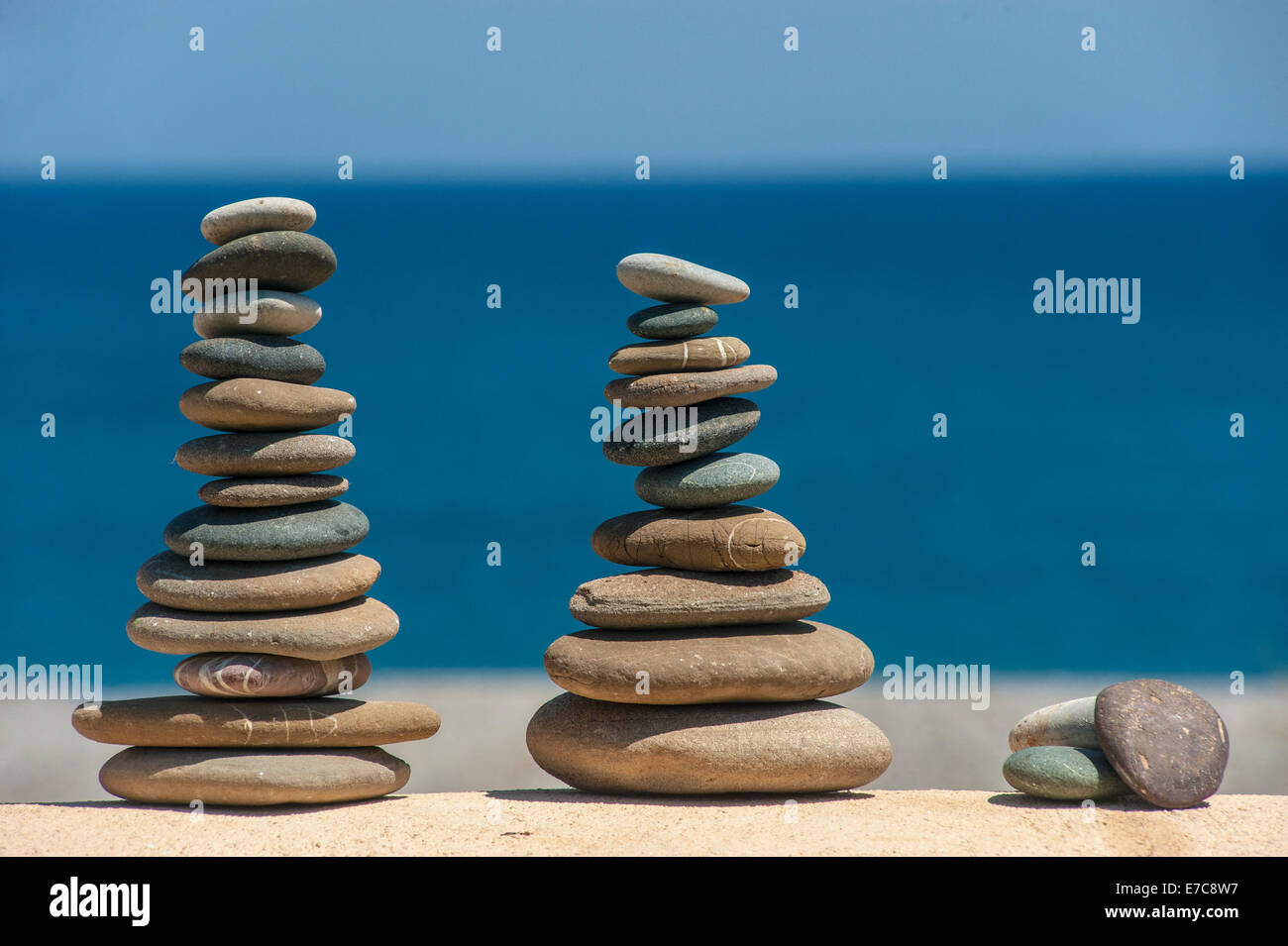 Two piles of pebbles on the coast with a blue sea Stock Photo - Alamy
