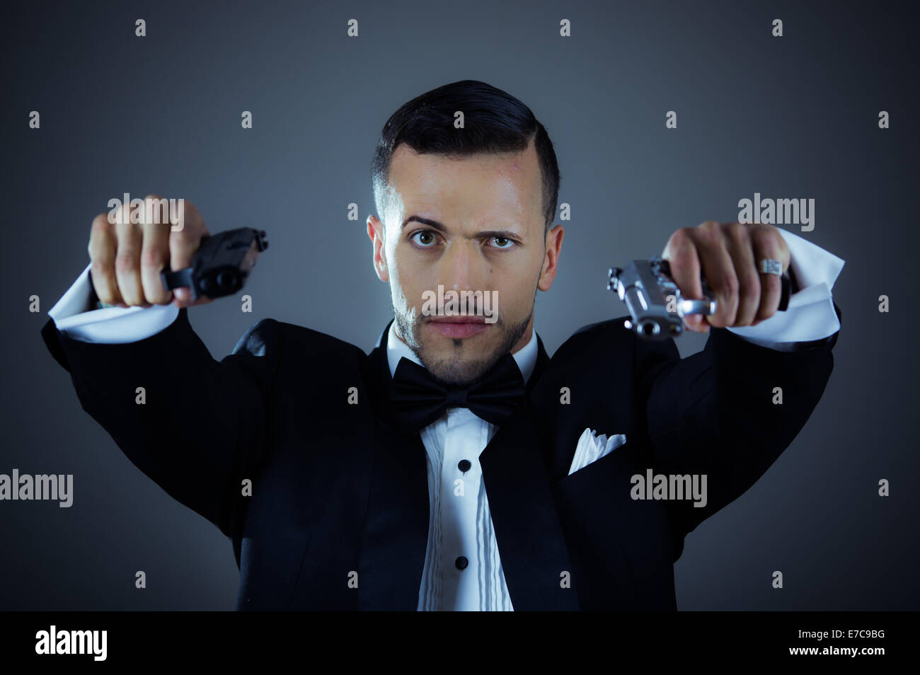 Handsome young man holding two guns Stock Photo - Alamy