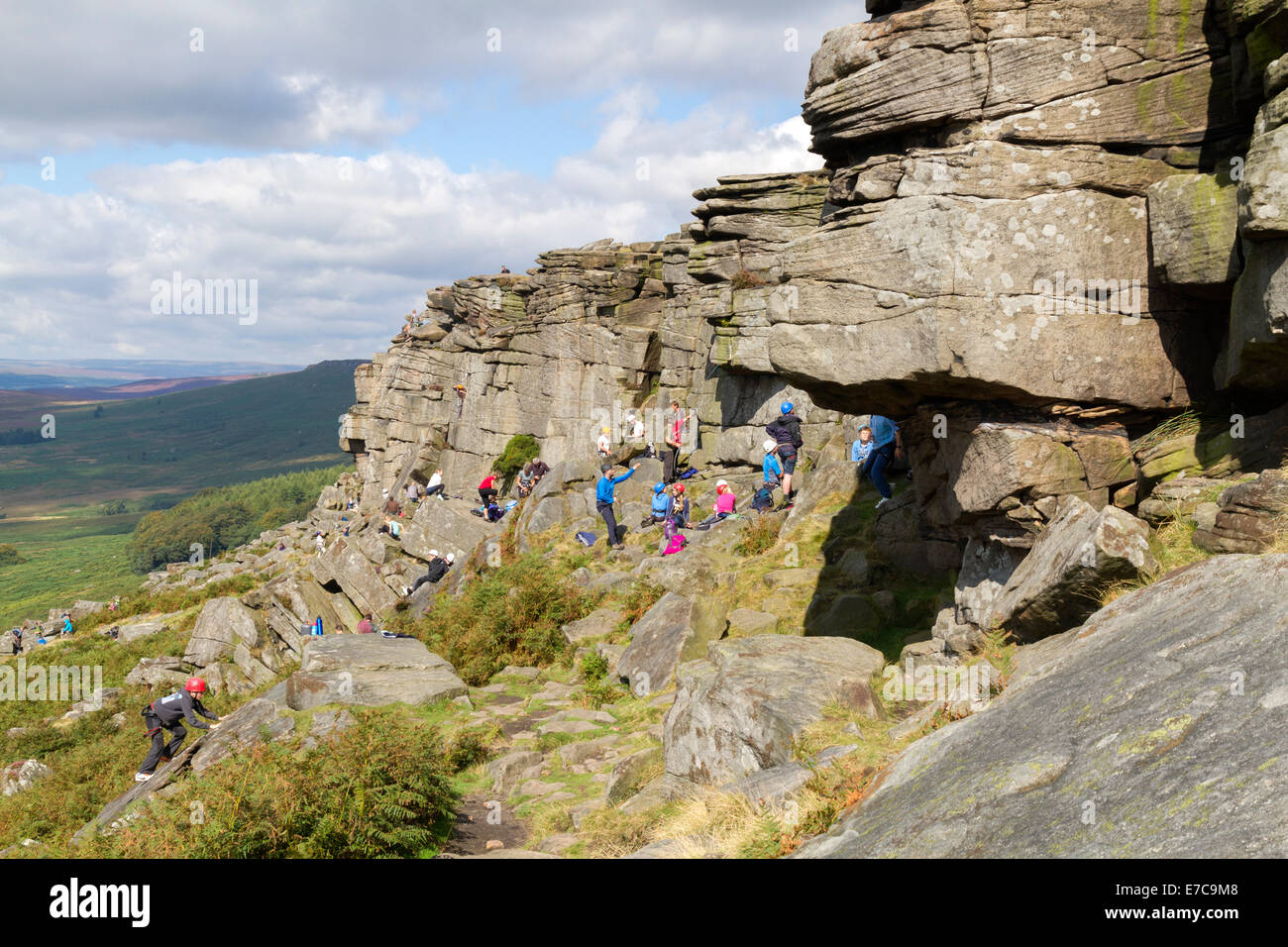 Large group of young people learning how to rock climb on Stanage Edge ...