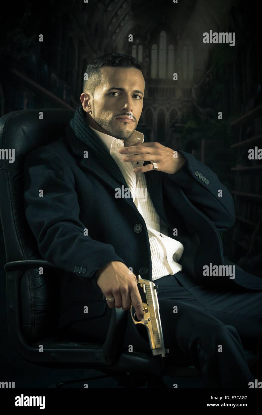Elegant man sitting in a chair holding gun over dark background Stock ...