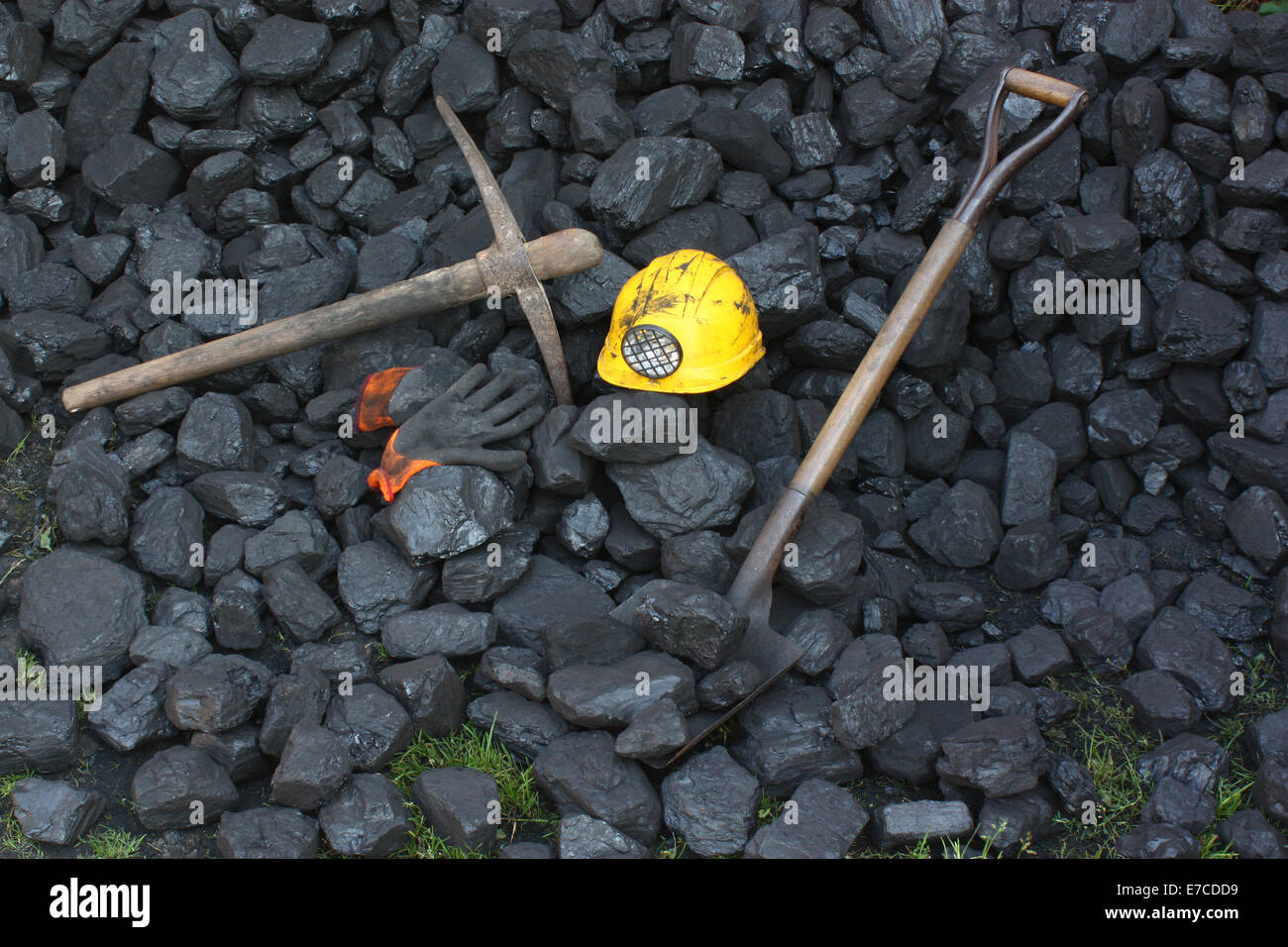 Shovel, pickaxe, gloves, mining helmet in the background heap of coal ...