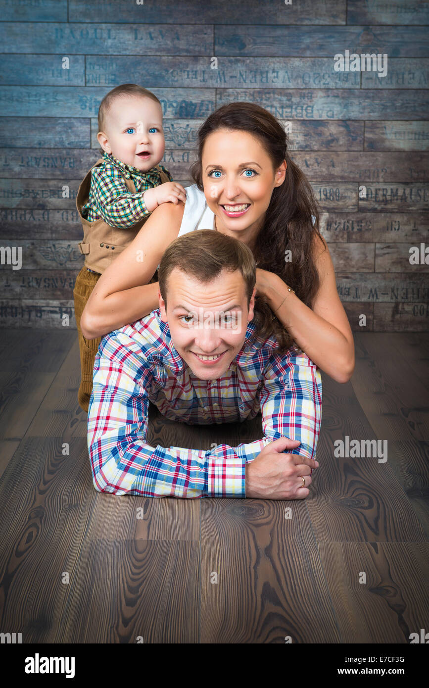 Family pyramid. Smiling dad, mom and son on background of boards Stock ...