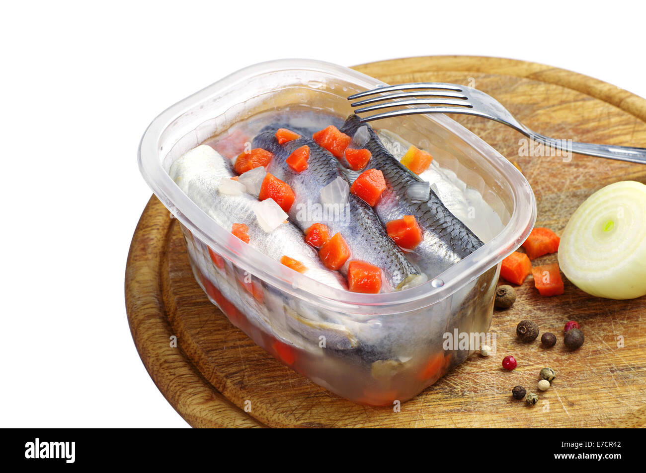 Marinated fish in plastic jar on a kitchen board, isolated on white ...
