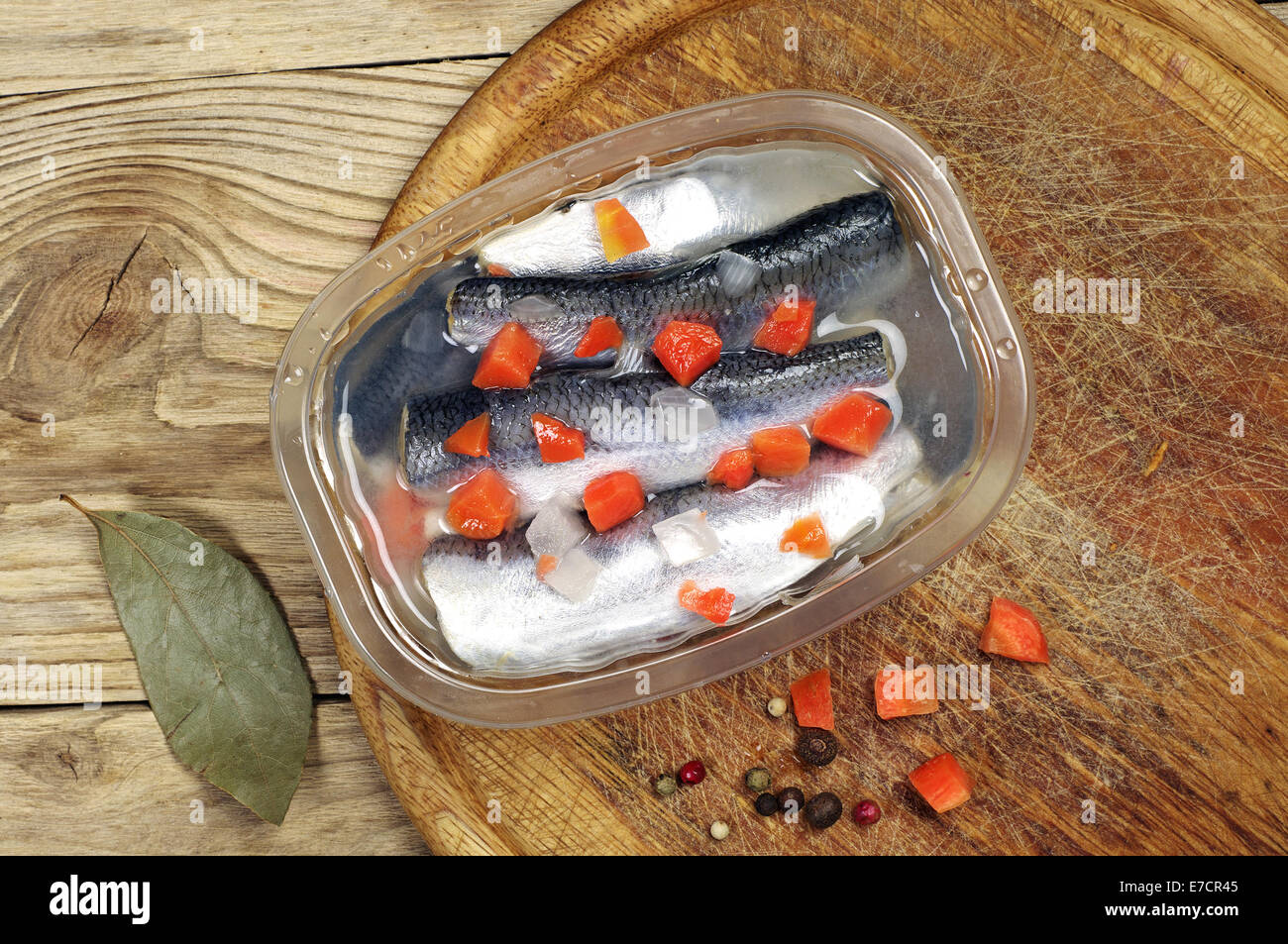 Marinated salted fish with carrots in jar on wooden table Stock Photo ...