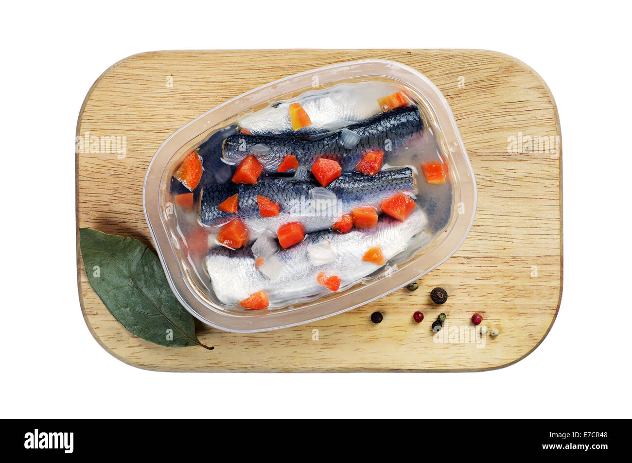 Marinated salted fish in plastic jar on a kitchen board, isolated on ...