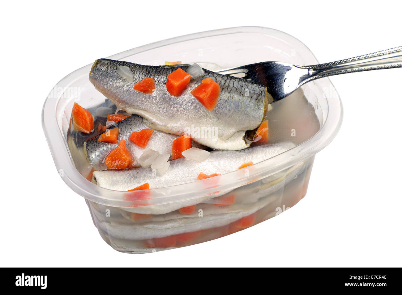 Marinated fish on a fork and in plastic jar isolated on white ...