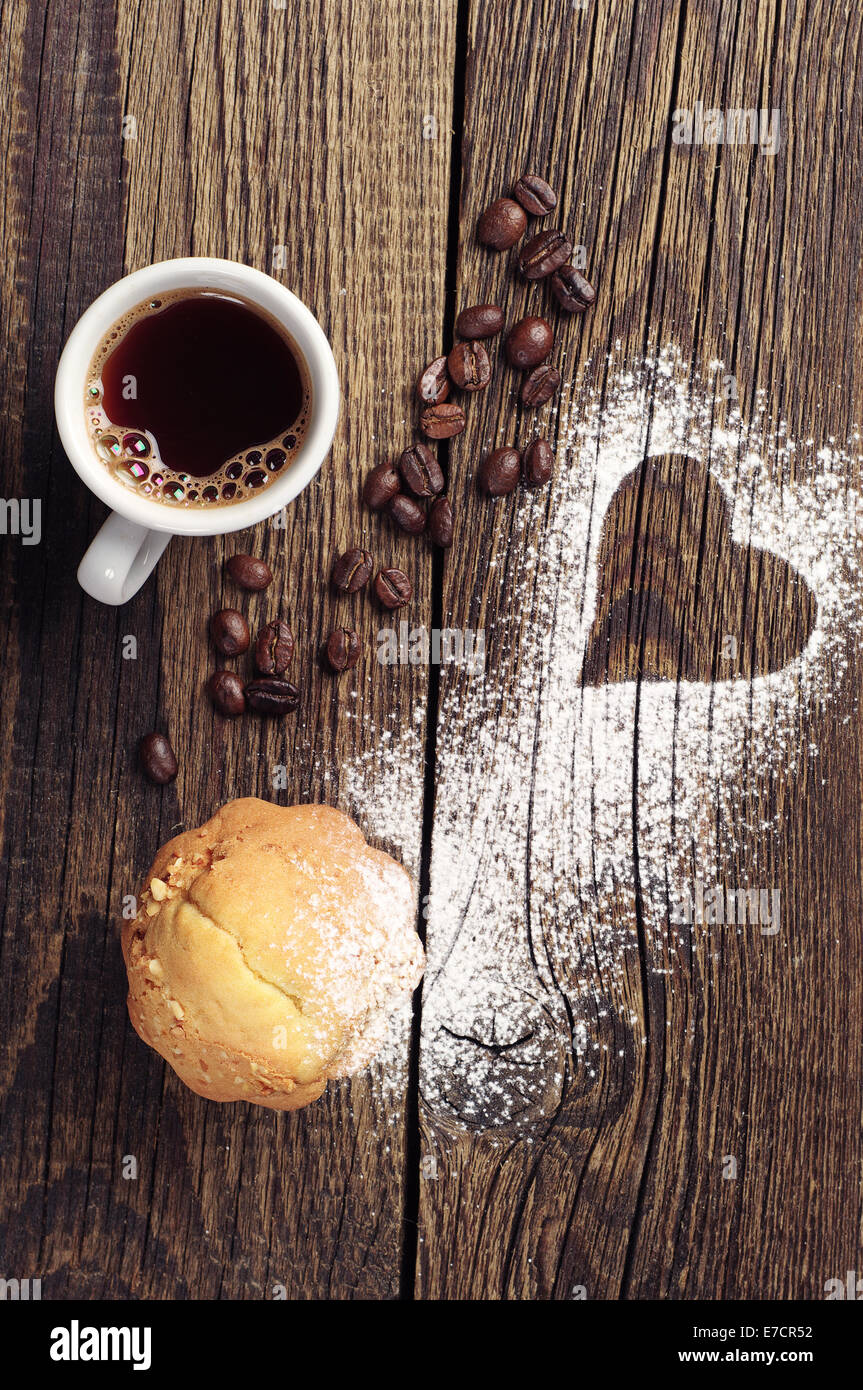 Cup of coffee and cupcake on vintage wooden background with heart Stock ...