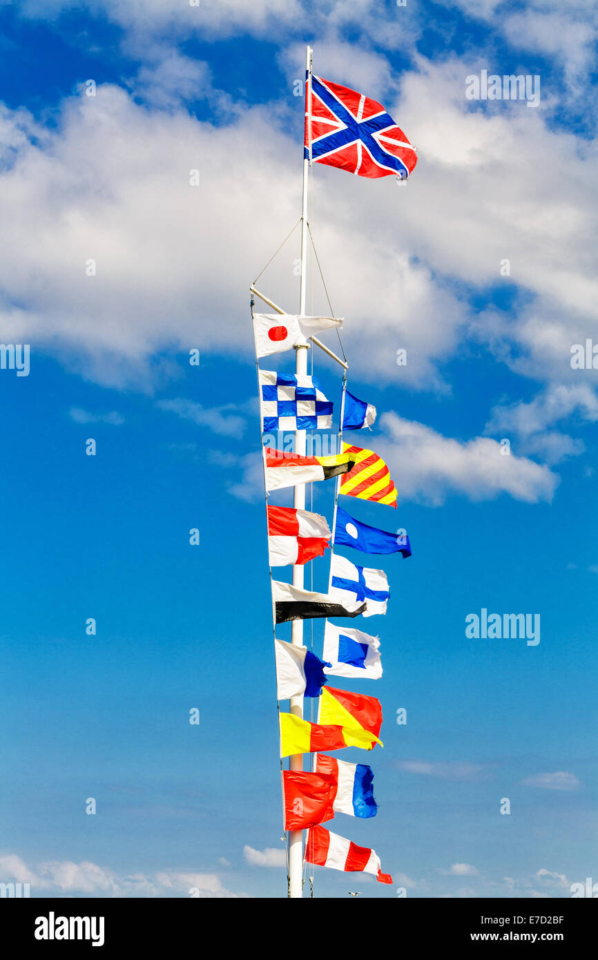 Flags of different countries on the flagpole waving in the wind against ...