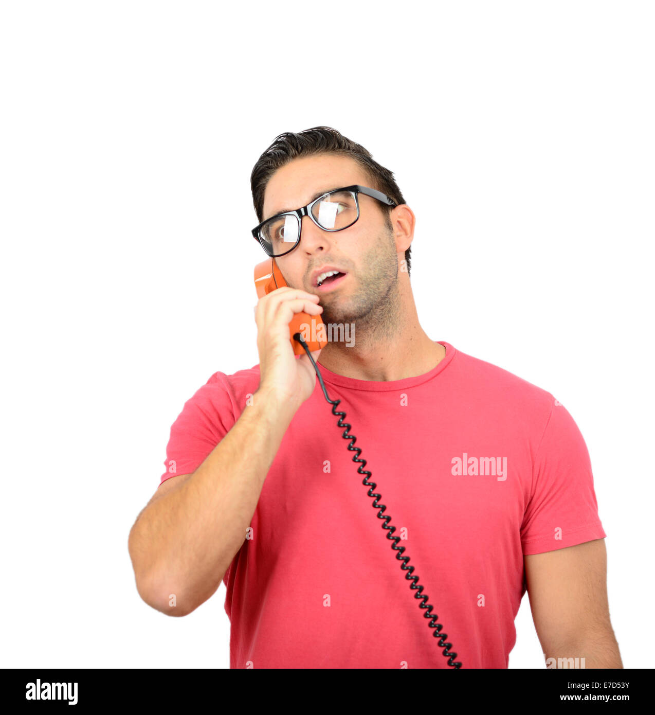 Portrait of young man in shock while talking on phone having unpleasant ...