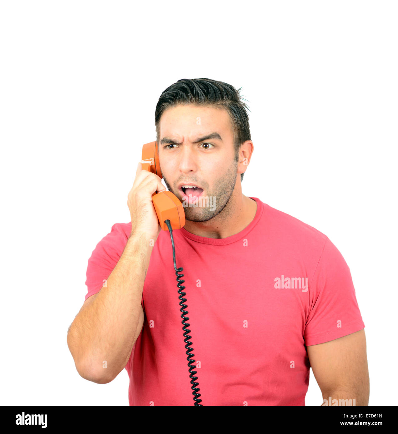 Portrait of young man in shock while talking on phone having unpleasant ...