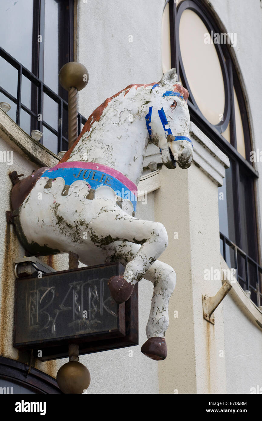 Wooden galloping horse attached to a wall on a closed down bar very run ...