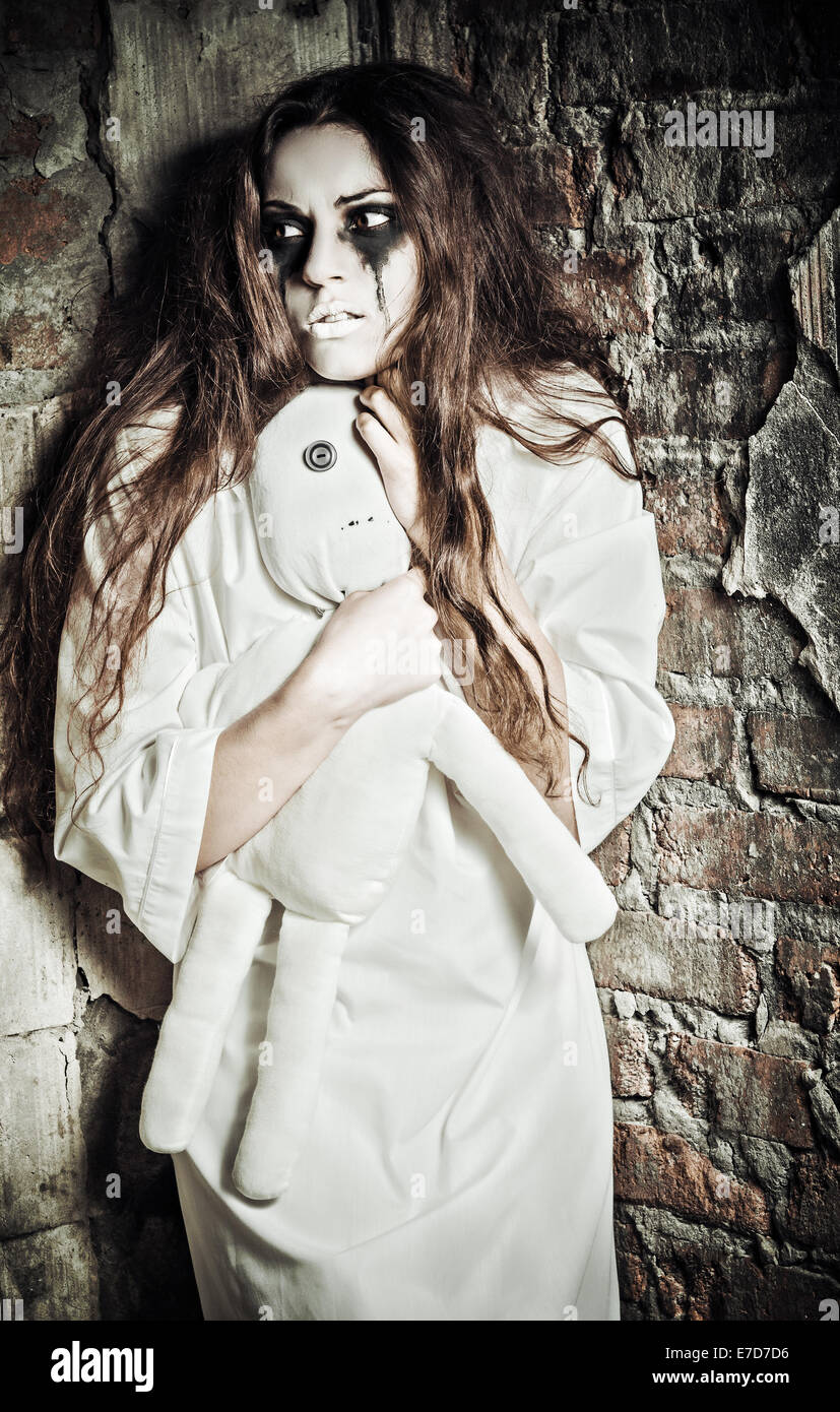 Horror scene: the strange crazy girl with moppet doll in hands Stock ...