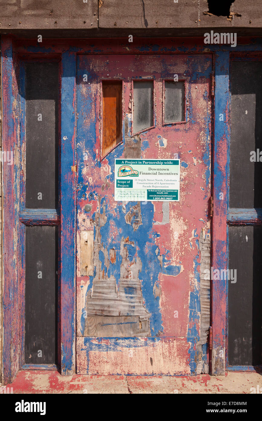 A very old derelict door with a sign talking about a restoration ...