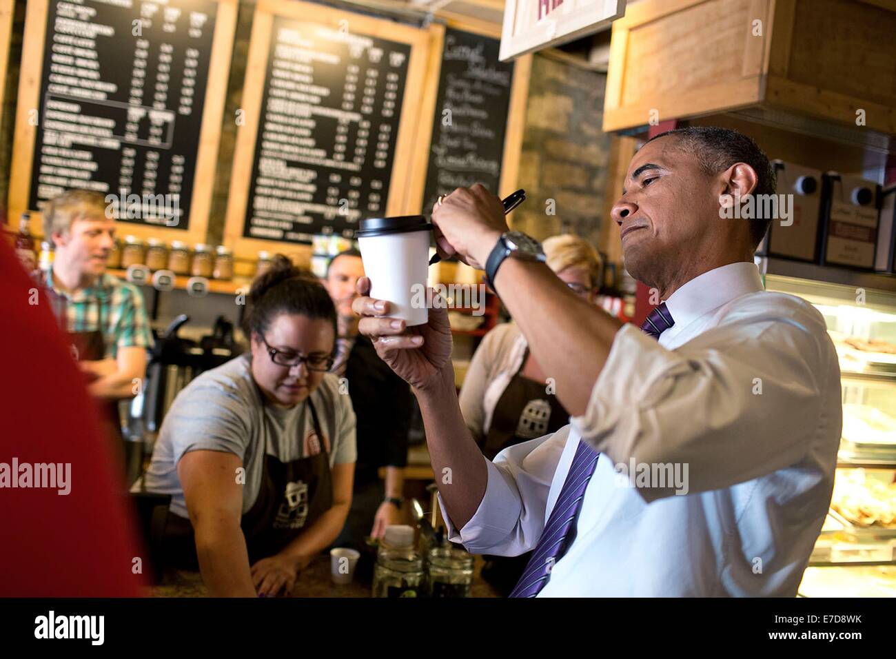 US President Barack Obama signs a coffee cup for a patron at Parkville ...