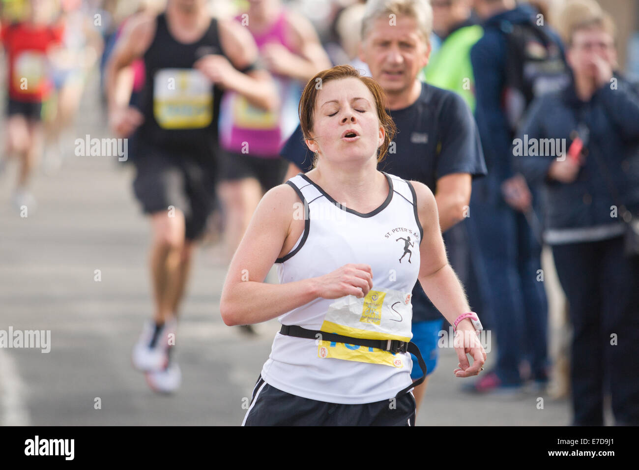 Belfast, Ireland. 14th Sept, 2014 A young woman crosses the finish line ...