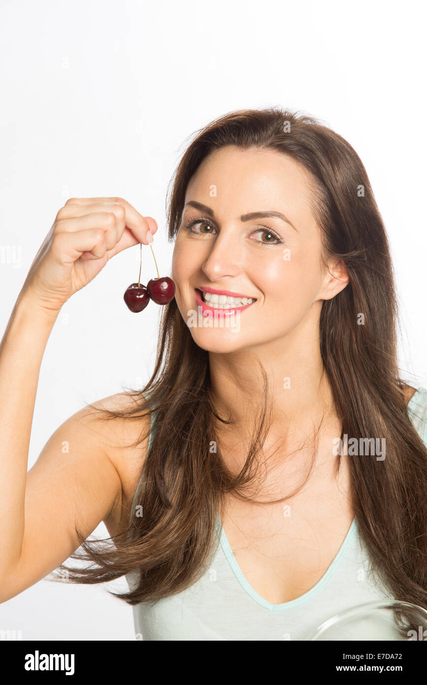 Portrait of a attractive woman eating cherries Stock Photo - Alamy