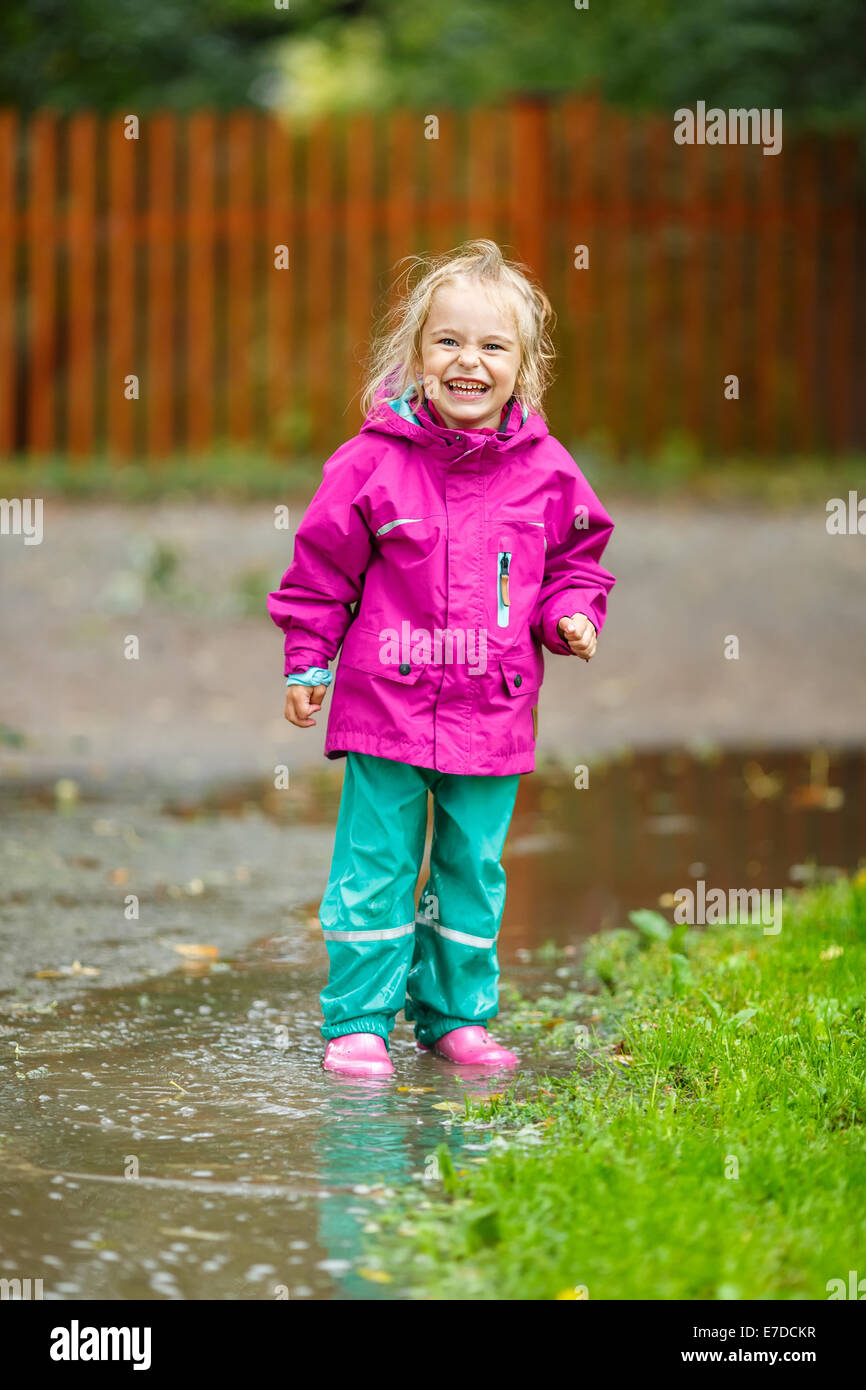 Happy little girl plays in a puddle Stock Photo - Alamy