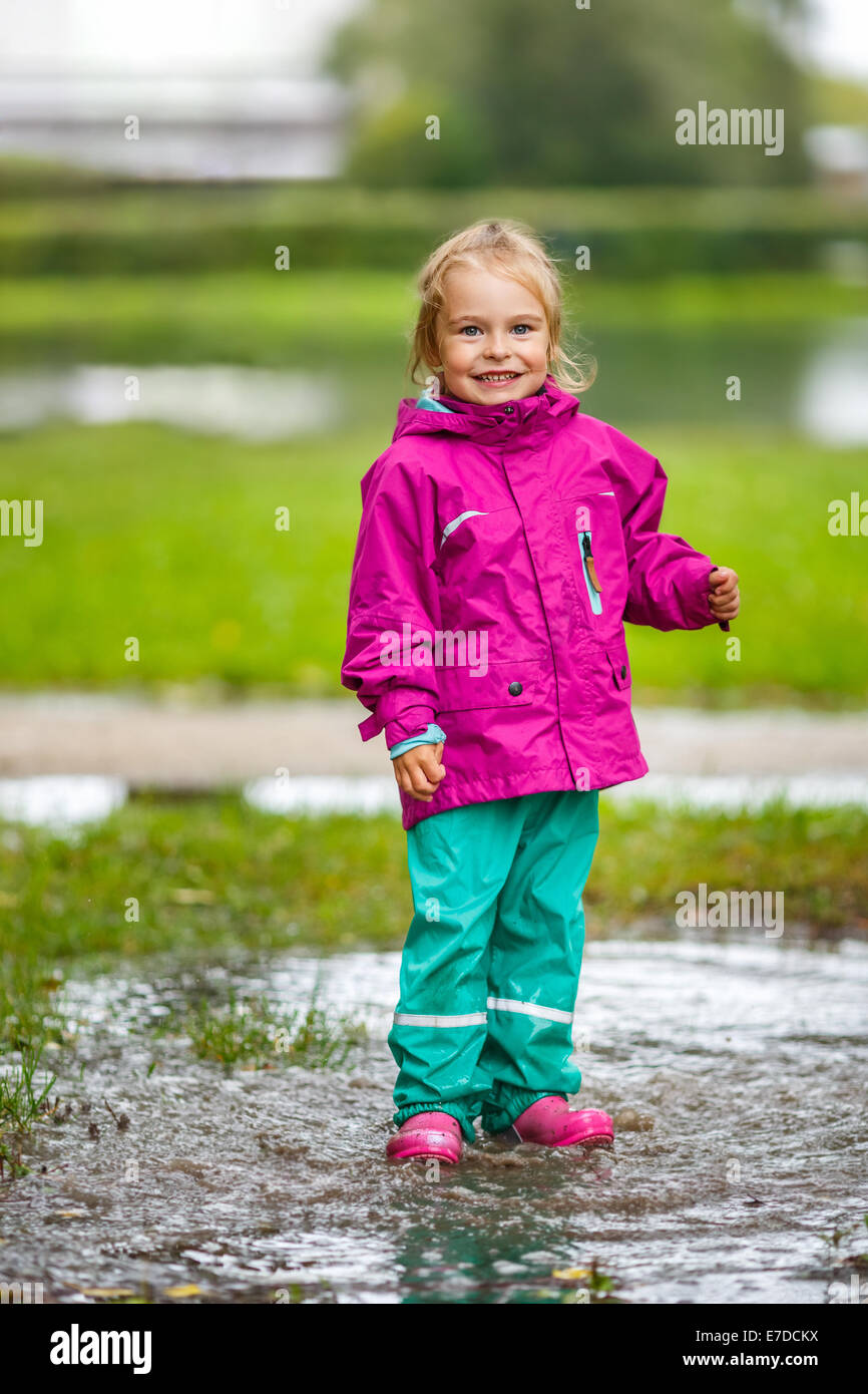 Happy little girl plays in a puddle Stock Photo - Alamy
