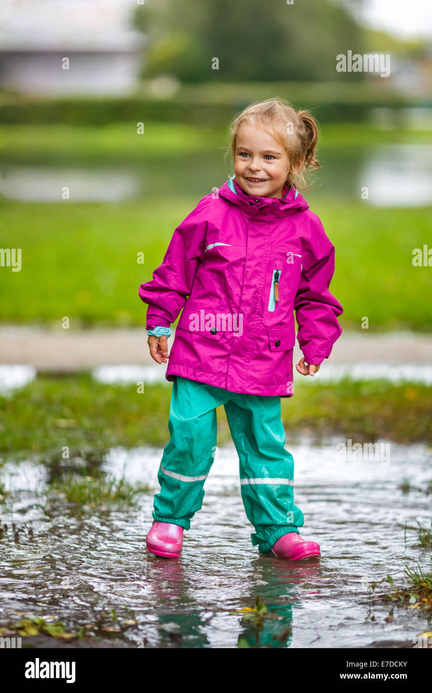 Happy little girl plays in a puddle Stock Photo - Alamy