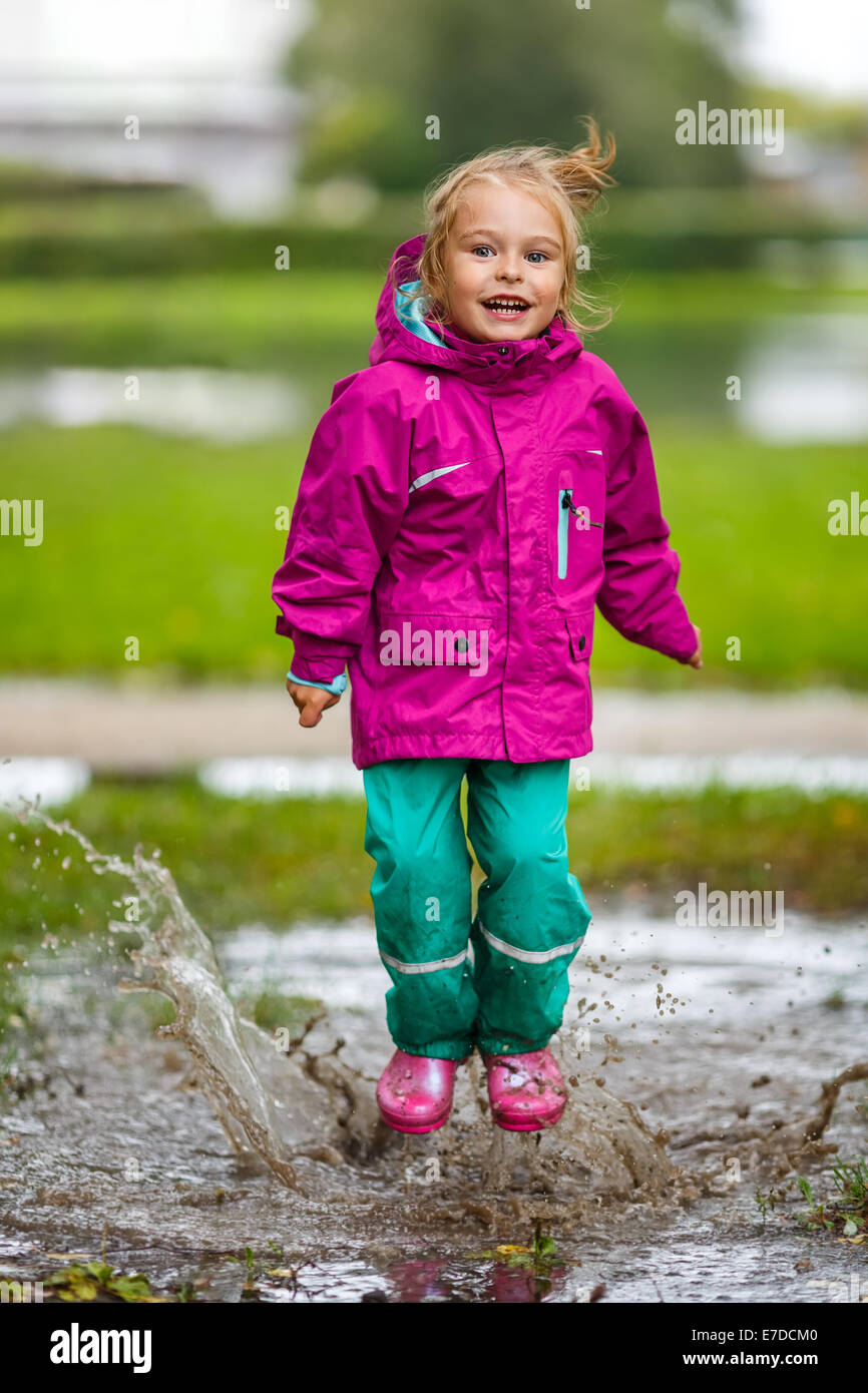 Happy little girl plays in a puddle Stock Photo - Alamy