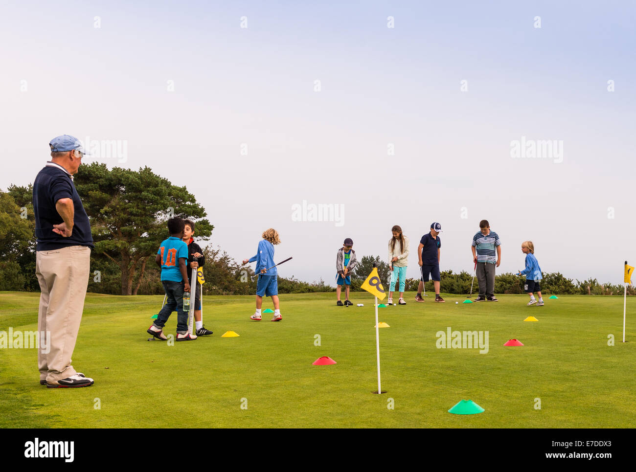 Young junior golfers are having a putting lesson on the practice ...